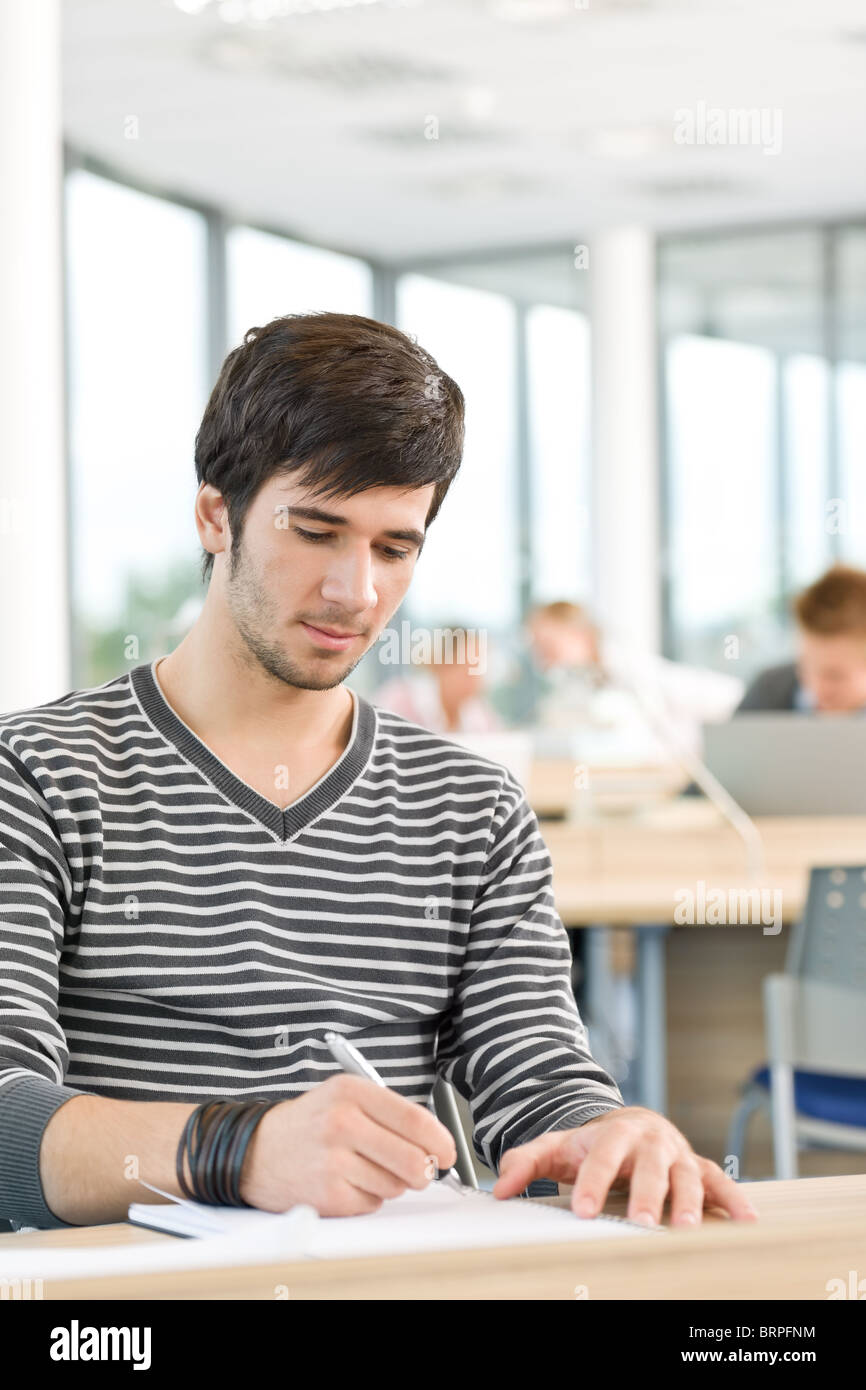 High school - Young male student write notes in classroom Stock Photo ...