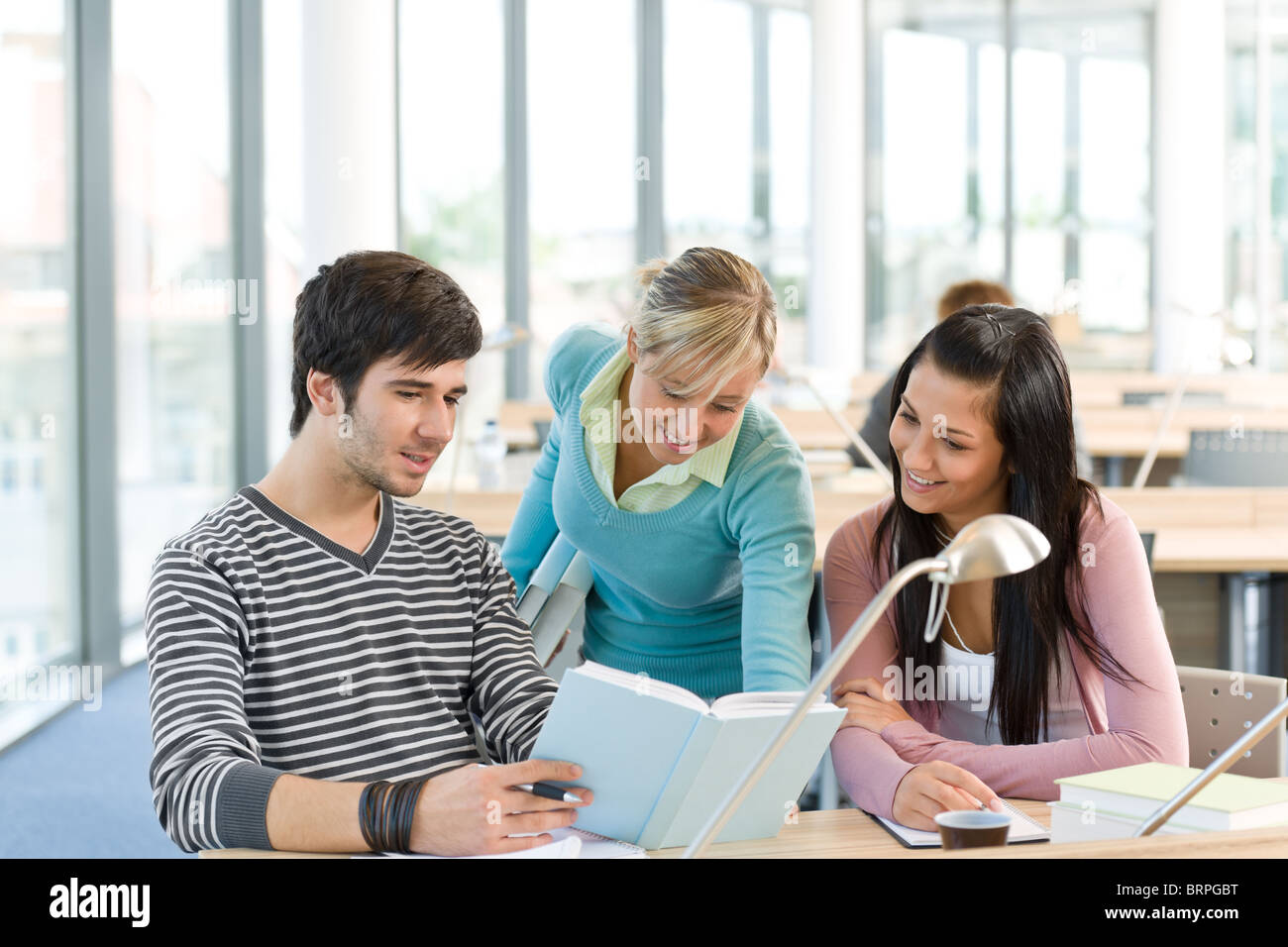 High school - three students with book in classroom Stock Photo - Alamy