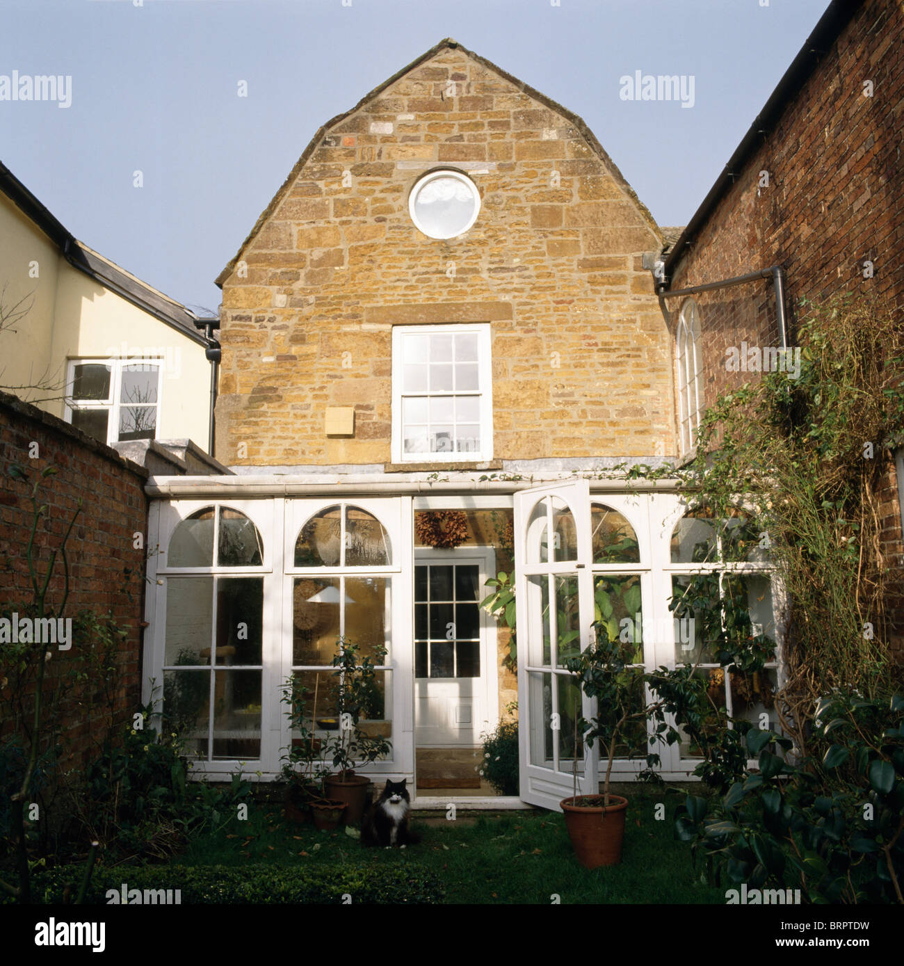 Small courtyard in front of conservatory hall extension on old stone ...