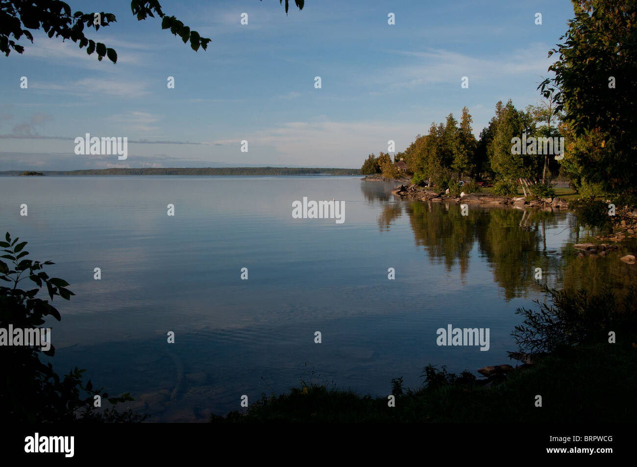 Reflections of the shore on Lake Manitou Stock Photo - Alamy