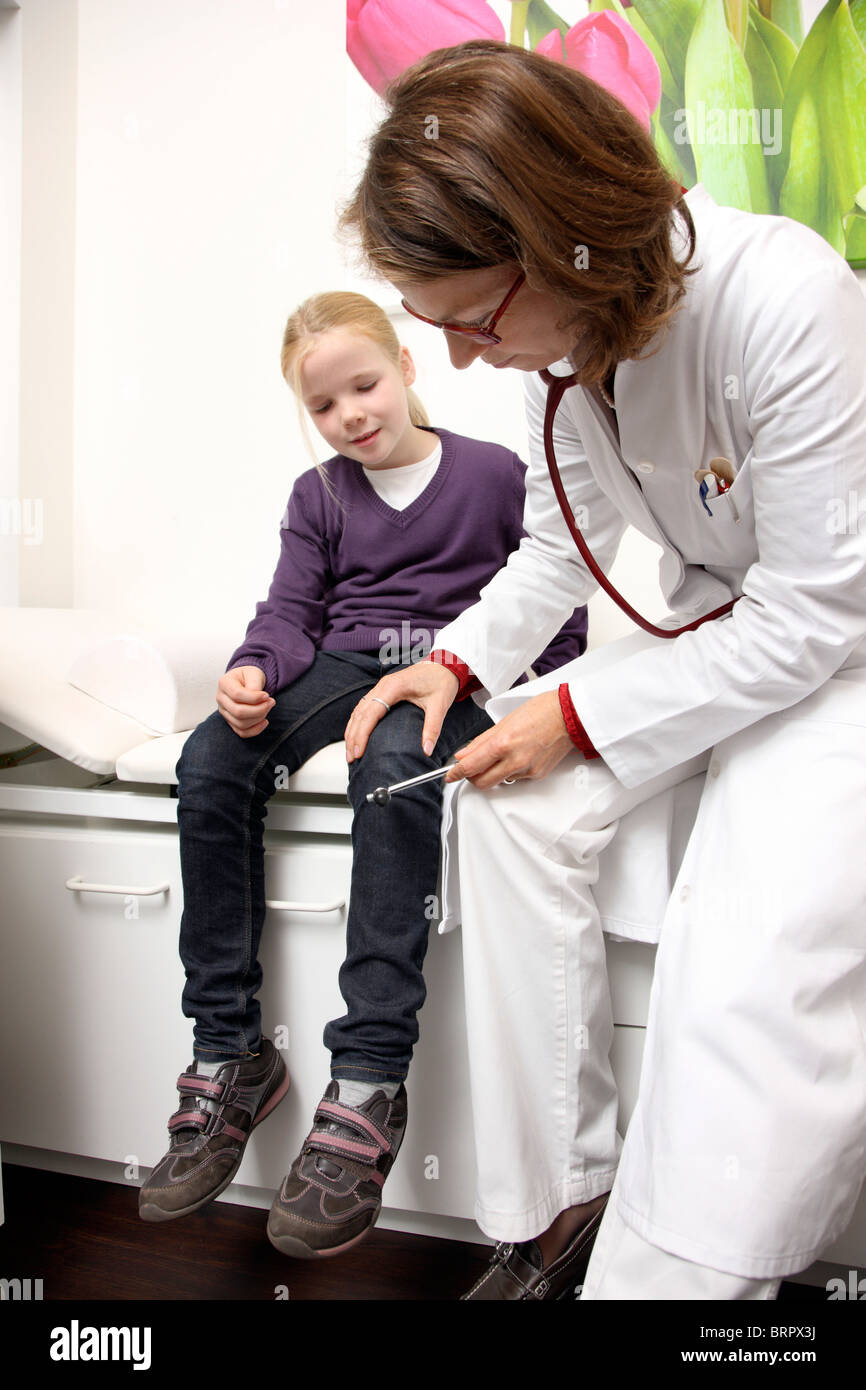 Doctors surgery. Check up examination of a young girl, knee reflex test ...