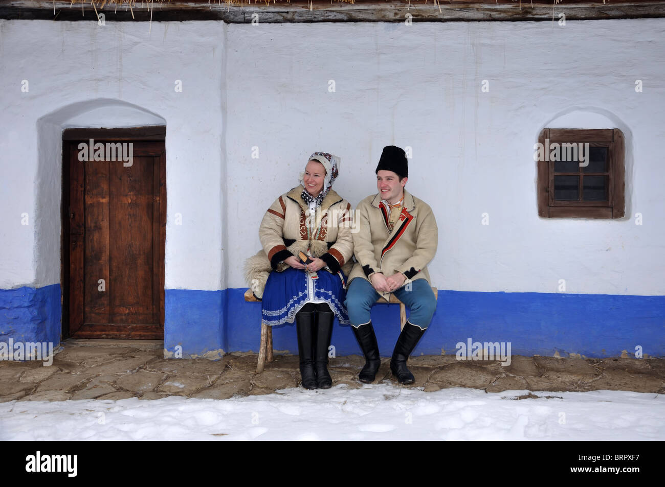 Rural celebration of Christmas. People in folk costume at cottage in ...