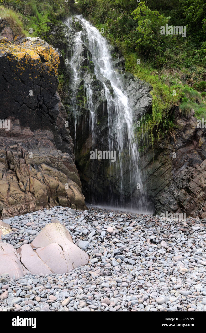 Clovelly Waterfall on a pebble beach at the conservation Village of ...