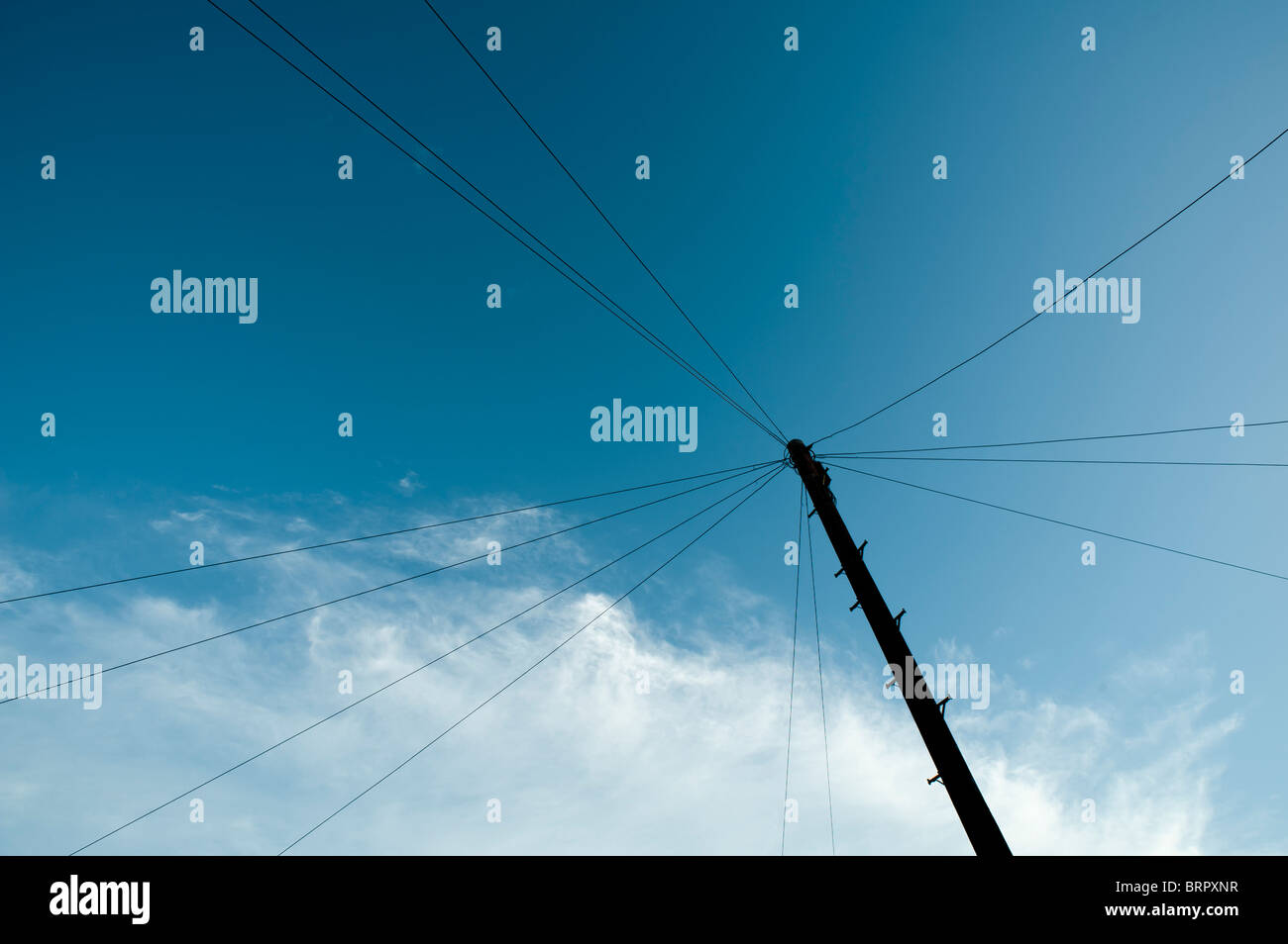 Telegraph pole with wires against blue sky with clouds Stock Photo - Alamy