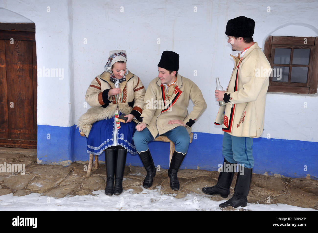 Rural celebration of Christmas. People in folk costume at cottage in ...