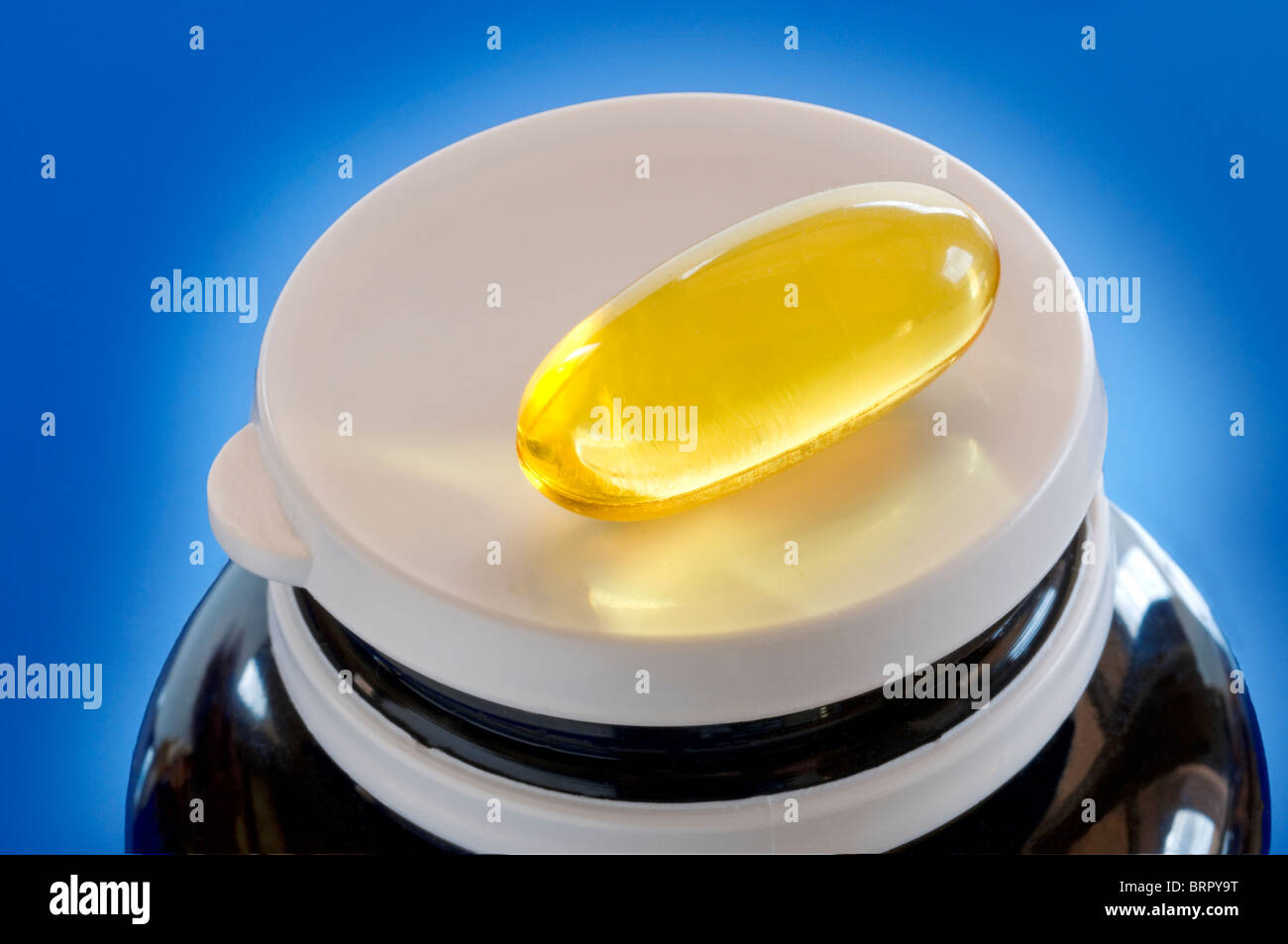 Single amber translucent gel cap sitting on top lid of prescription ...