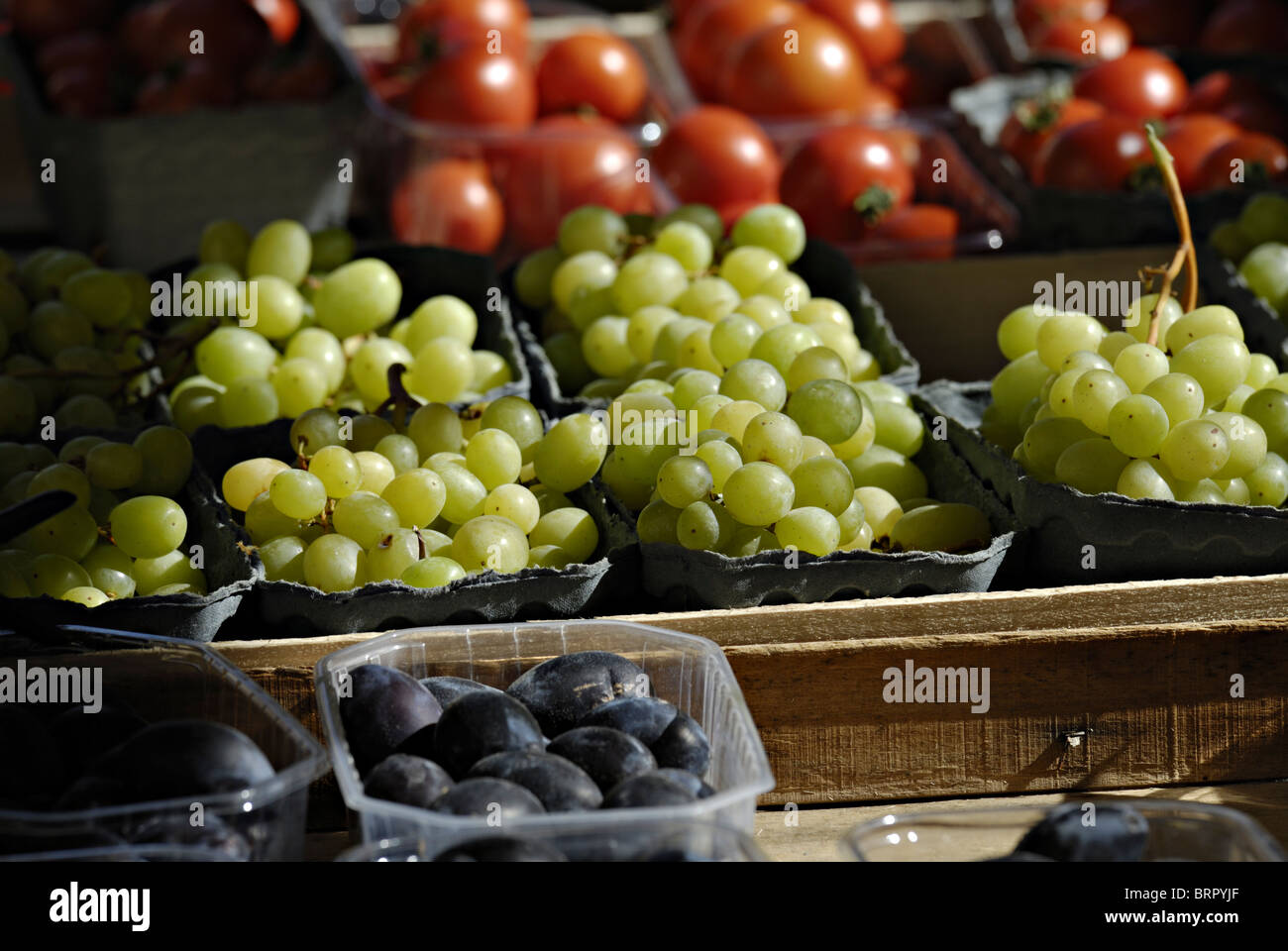 Marketplace organic fruits stall with plums tomatoes and grapes Stock ...