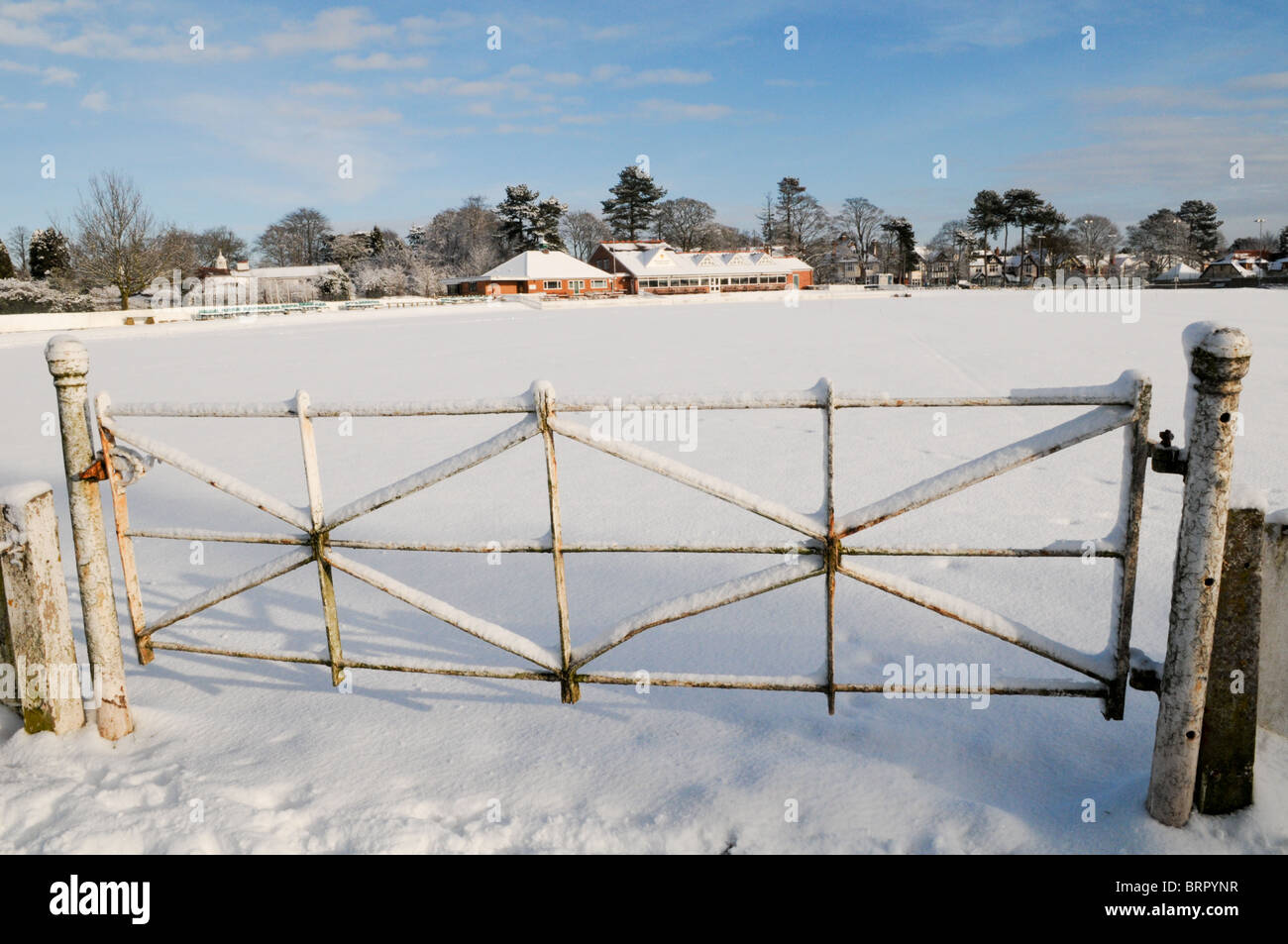 White decorative iron gate on the edge of a snow-covered pitch at ...