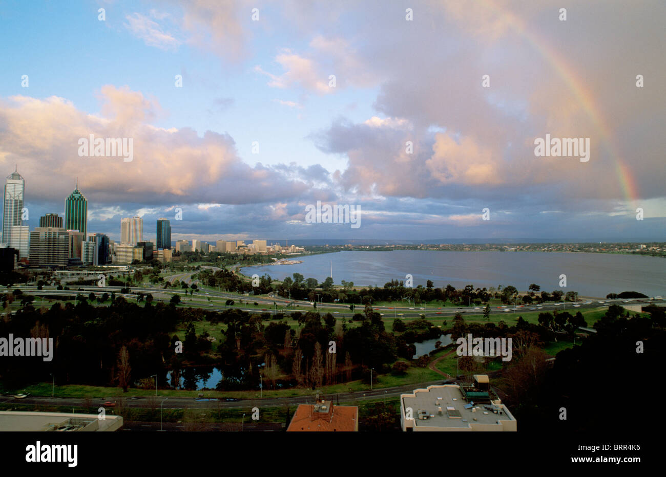 Perth city skyline and harbour at dusk and a rainbow in the background ...