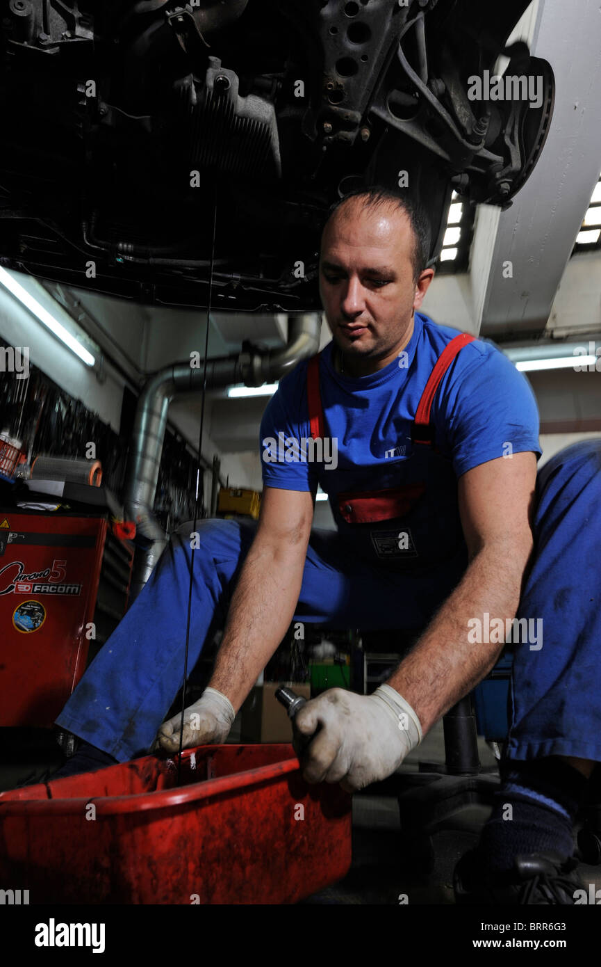 Car workshop with mechanic at work Stock Photo - Alamy