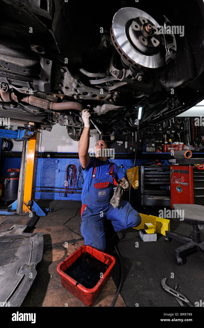 Car workshop with mechanic at work Stock Photo - Alamy