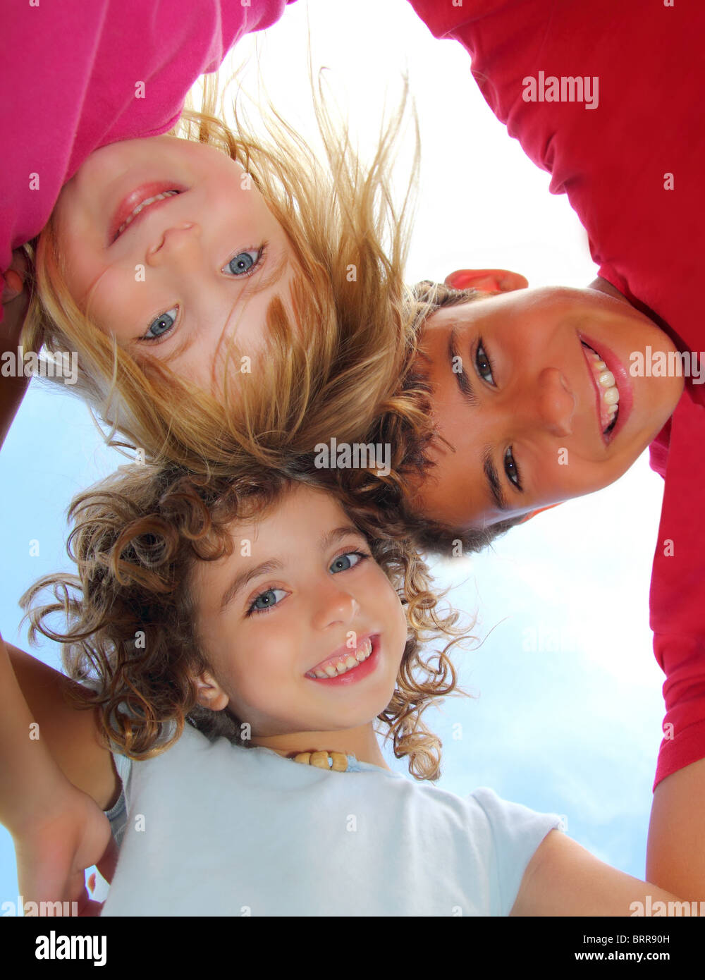 Below view of happy three children embracing hug each other smiling ...