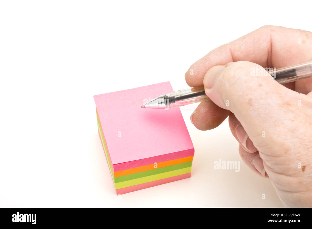 Block of vibrant multicoloured Post it Notes isolated on white with ...