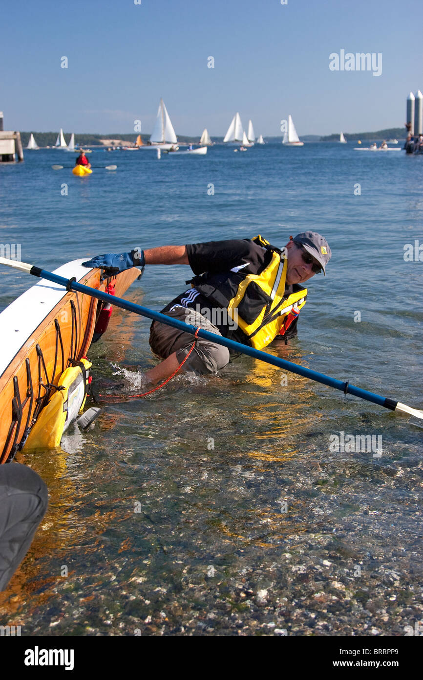 Man in life jacket falling out of kayak at beach during Wooden Boat ...