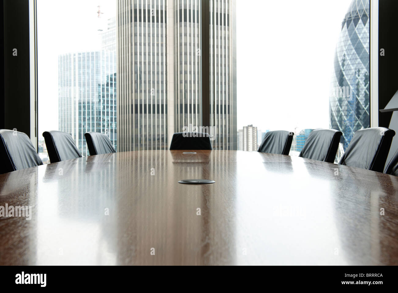 view of boardroom table with chairs and city buildings in background ...