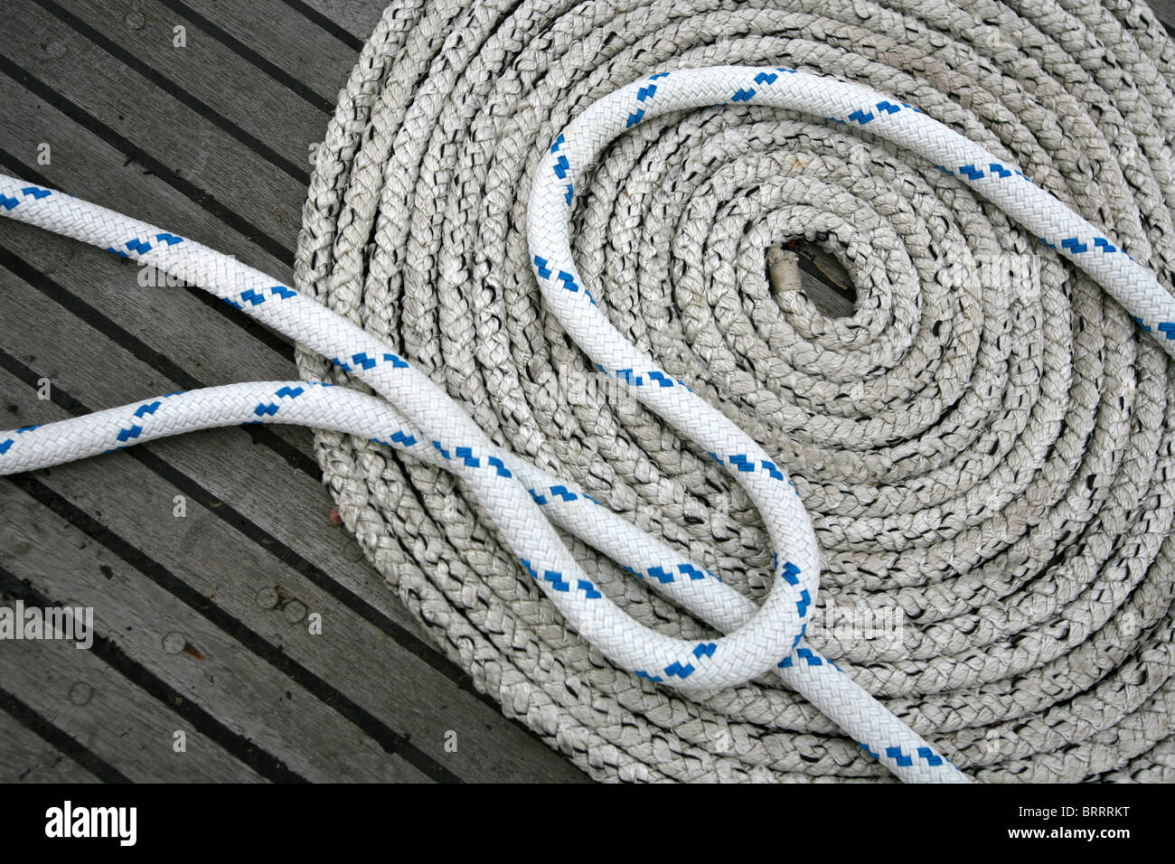 Nautical ropes coiled up on the deck of a boat Stock Photo - Alamy