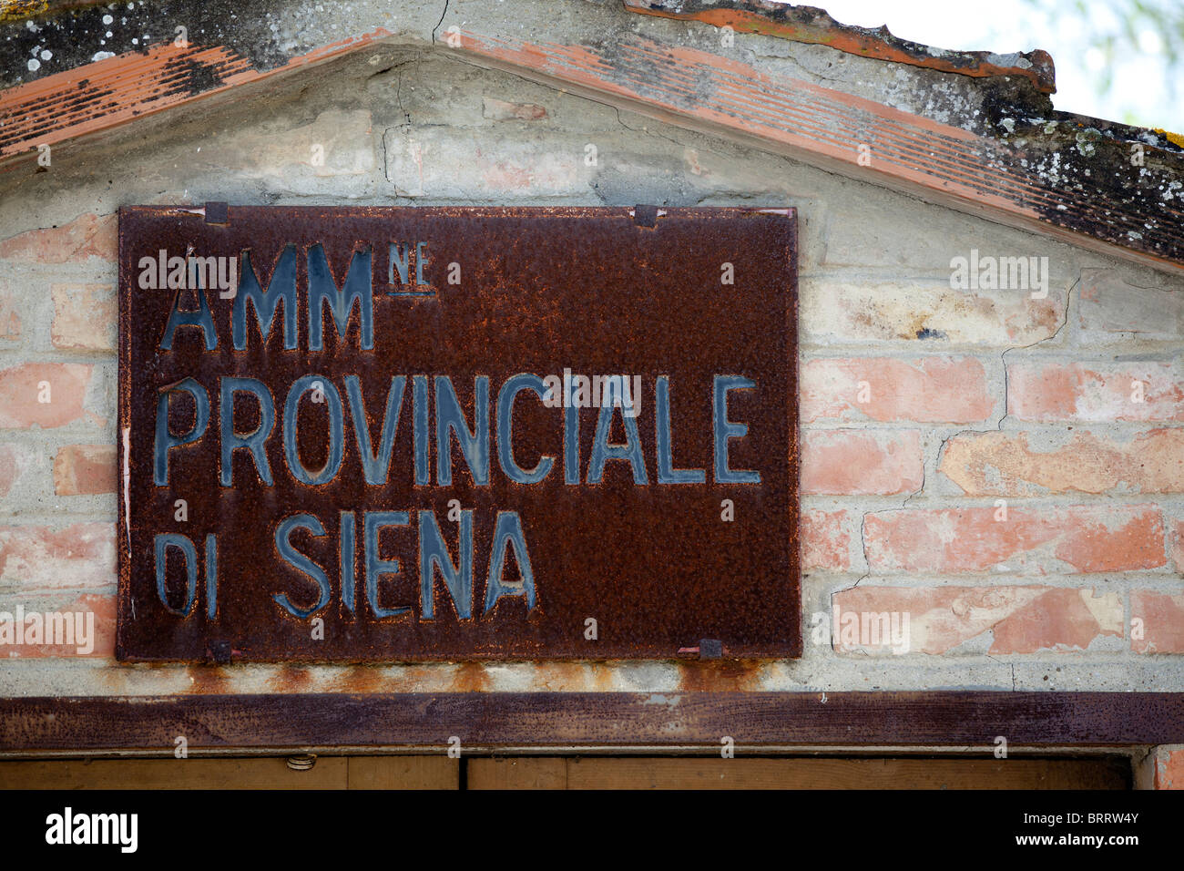 A rusty old provincial sign for the Sienna district in Italy attached ...