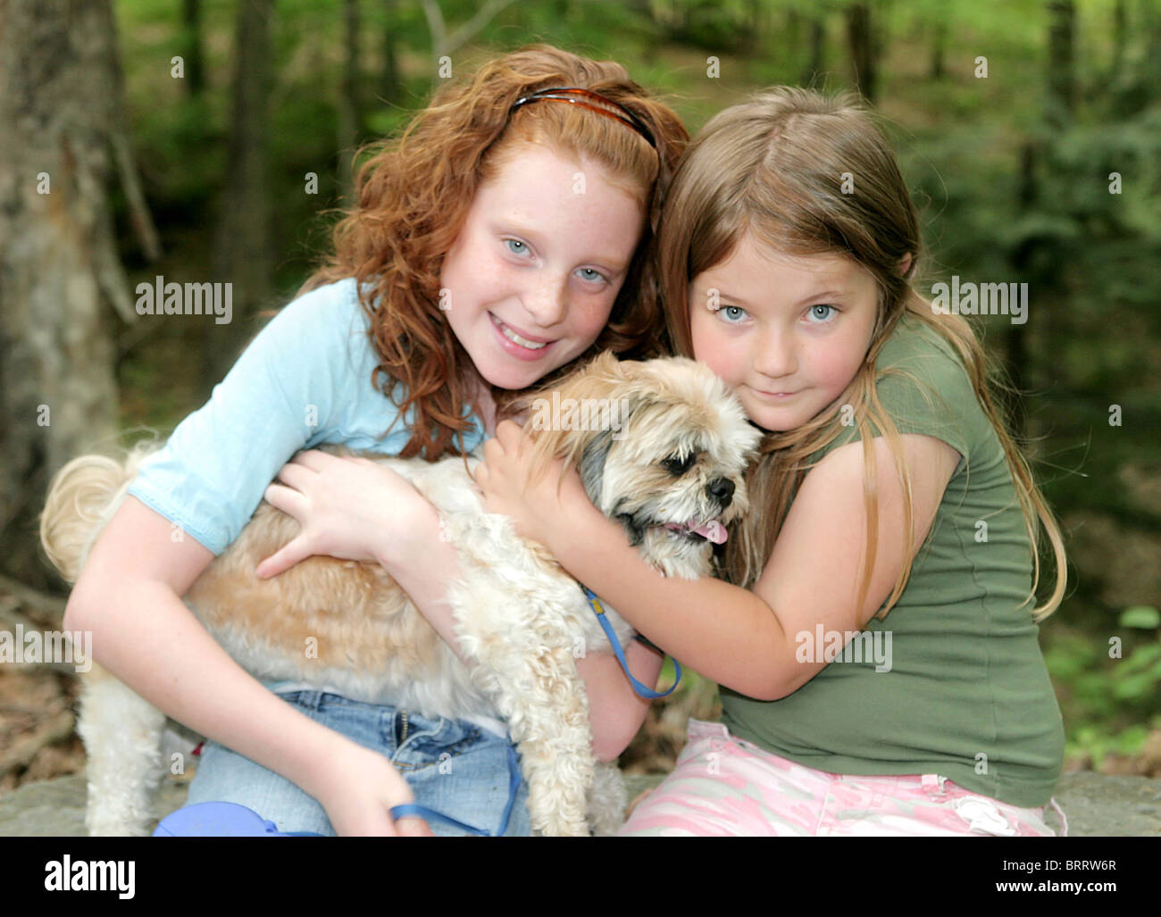 two young female children hugging a dog outdoors Stock Photo - Alamy
