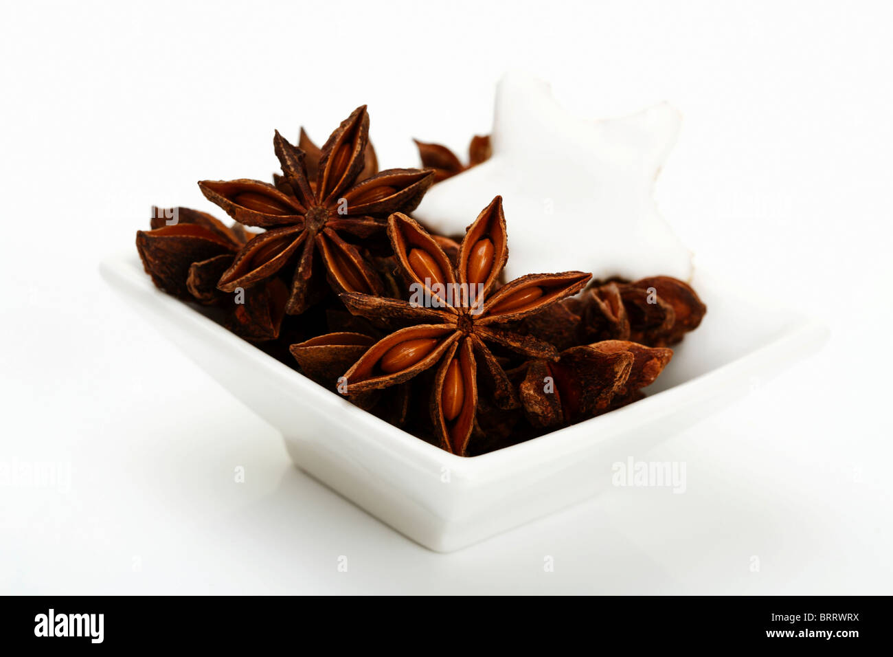 Anise stars with star-shaped cinnamon cookie in a white bowl Stock ...