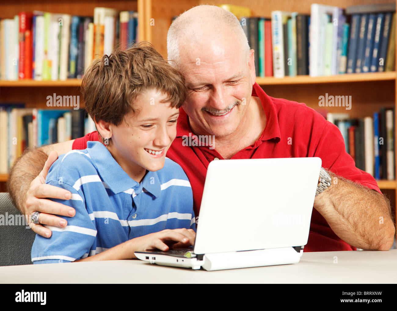 Father and son in the library using a small netbook computer Stock ...