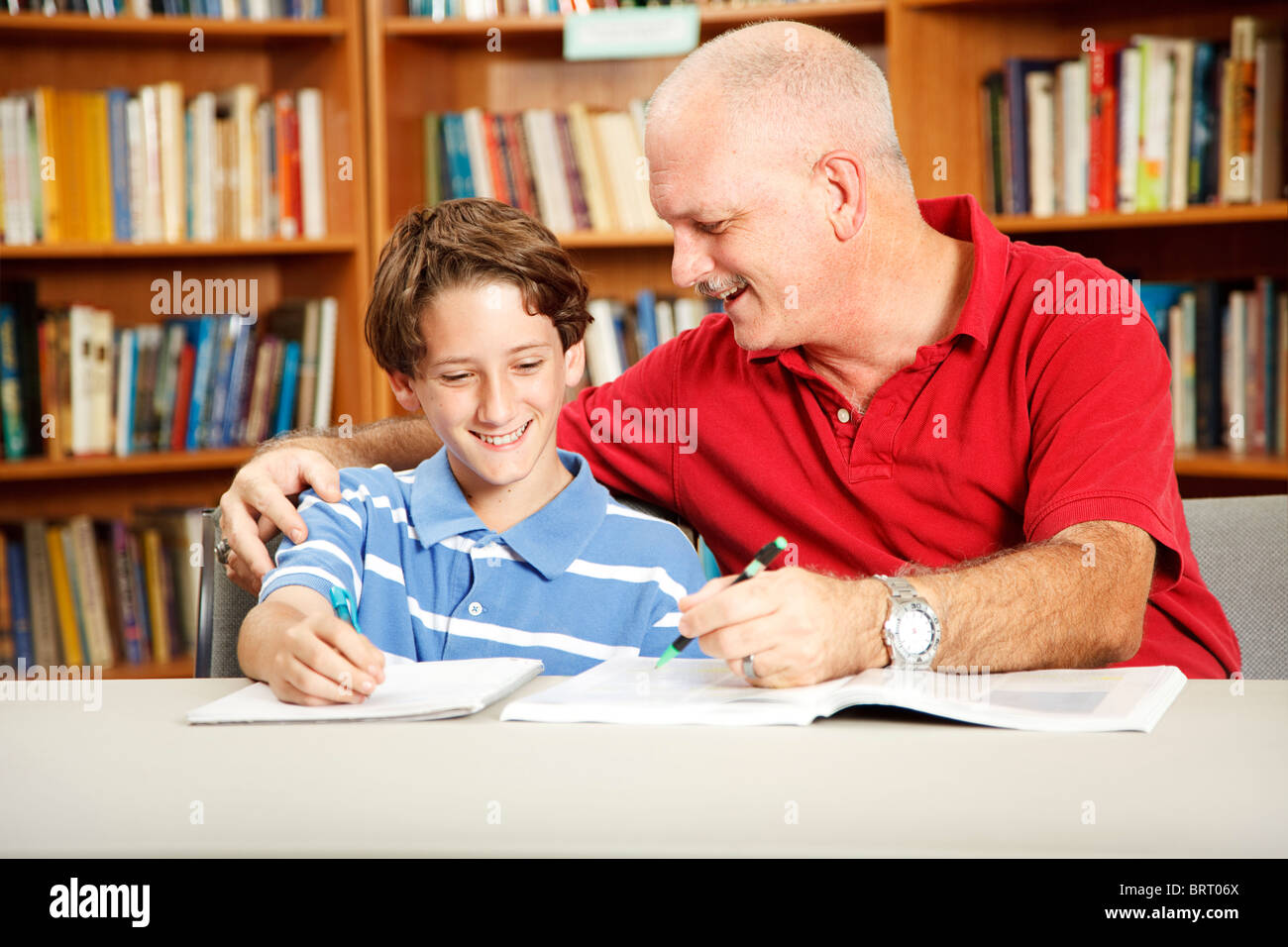 Father helping with his son's homework, in the school library Stock ...
