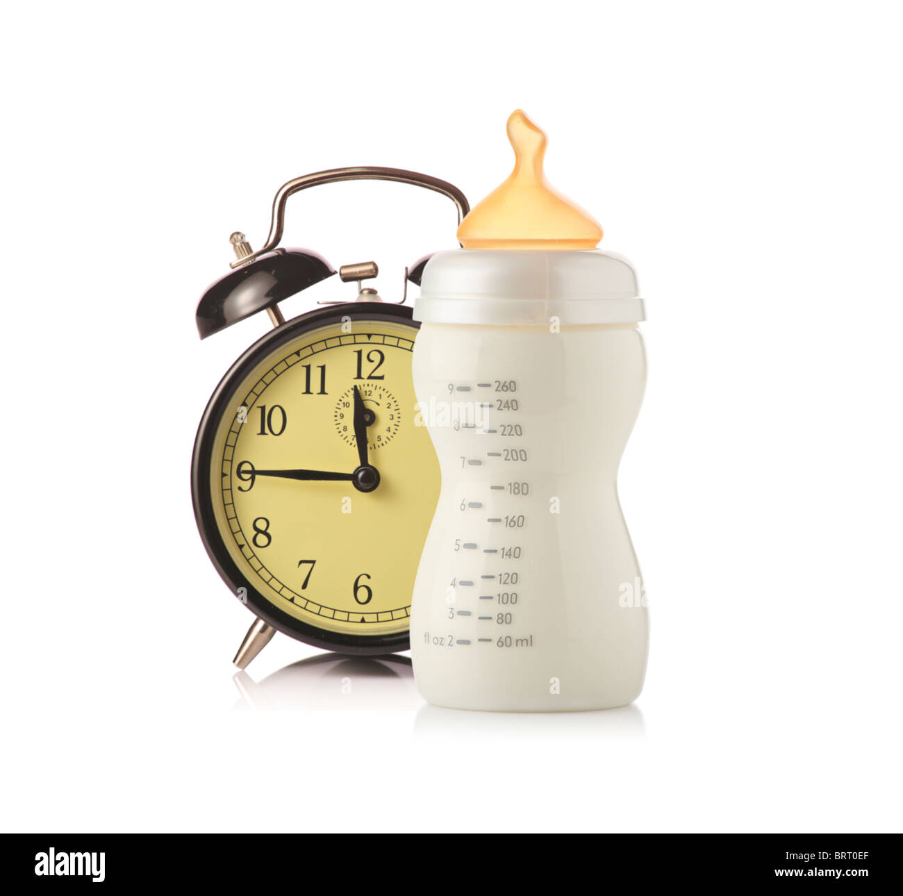 Alarm clock and baby feeding bottle with milk Stock Photo - Alamy