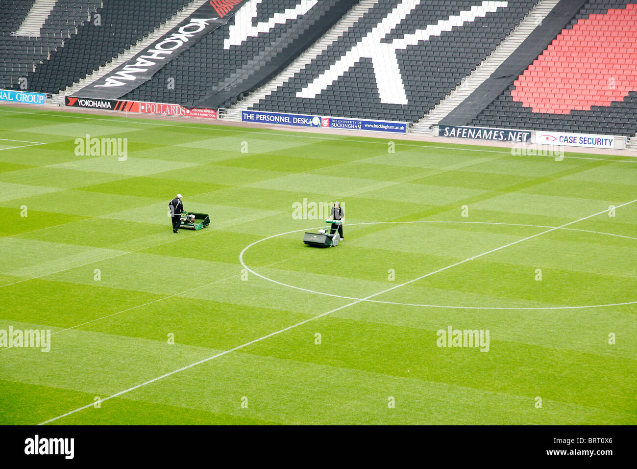 Two groundsmen cutting the grass at Milton Keynes football stadium ...