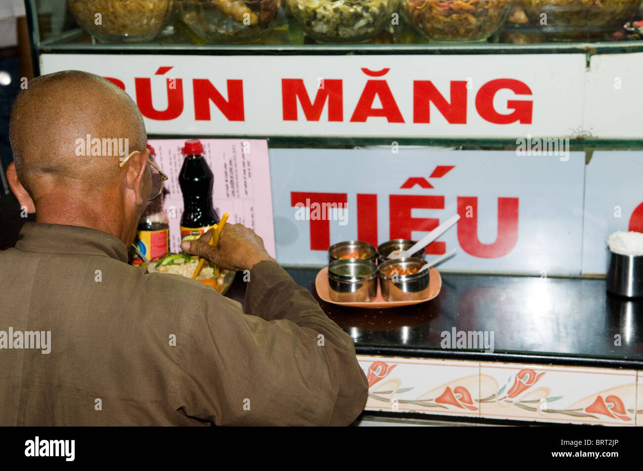 An old Vietnamese man enjoys his traditional noodle soup dish known as ...