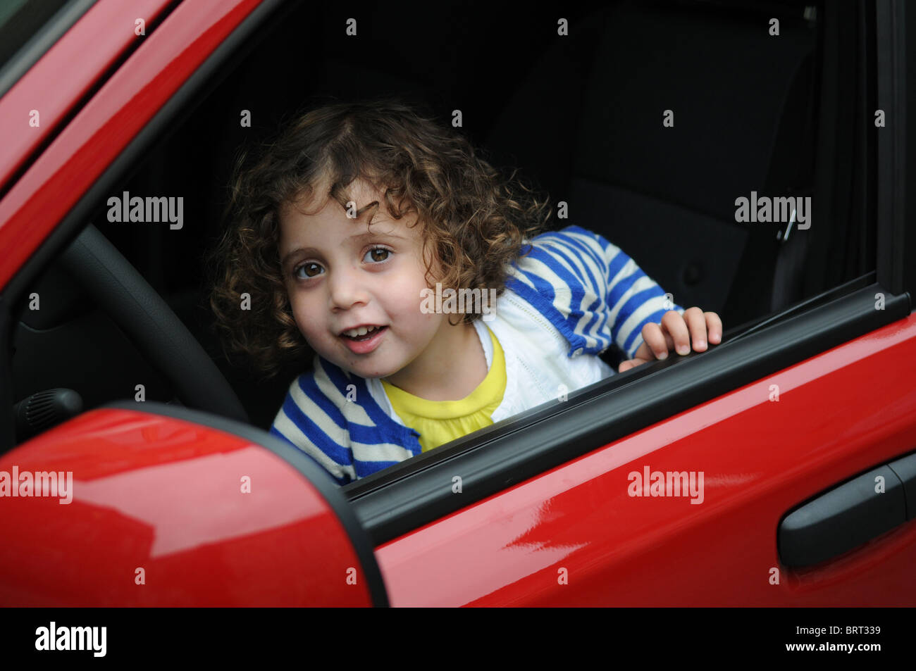 happy little girl inside red car Stock Photo - Alamy
