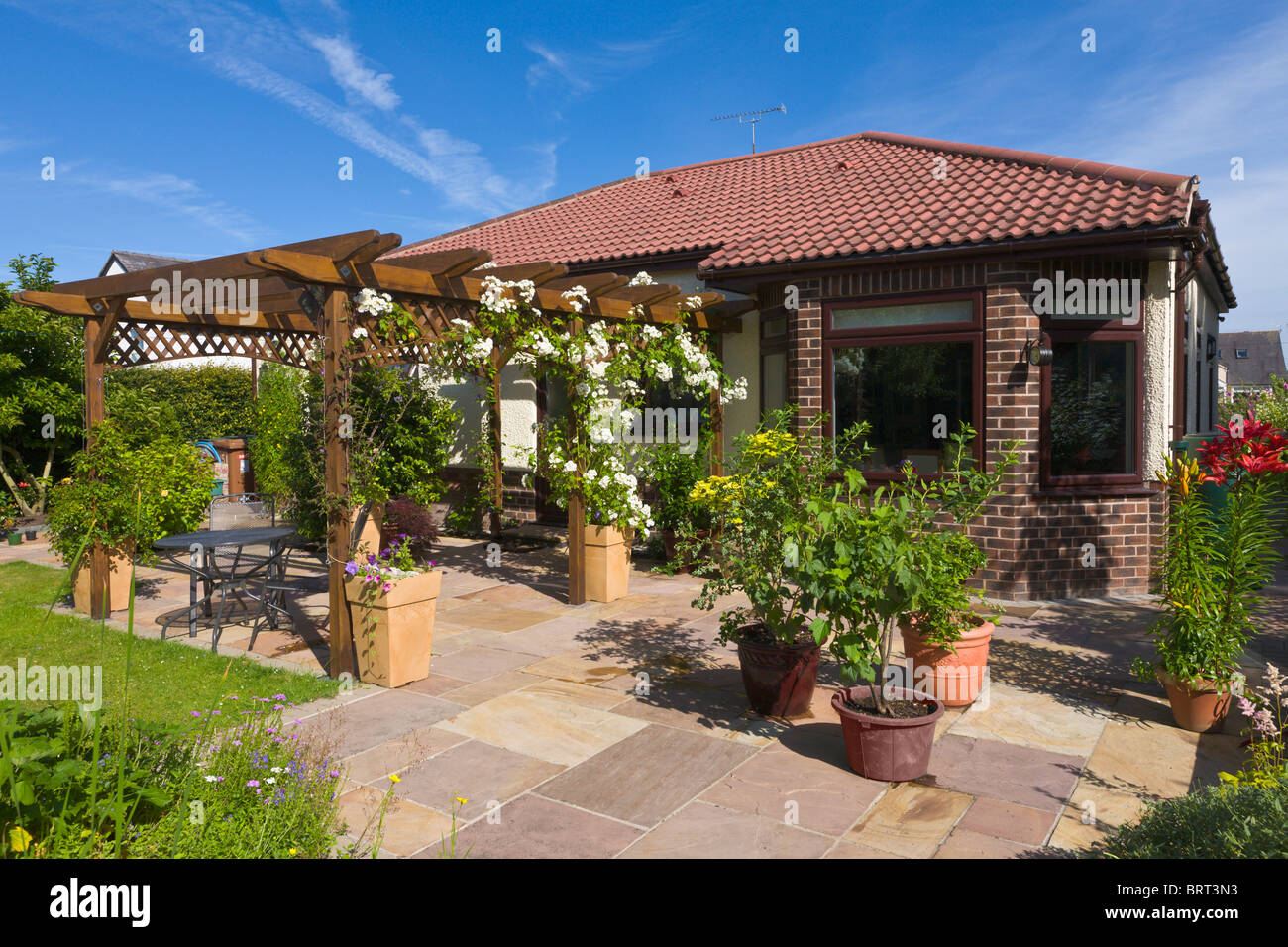 Back garden of bungalow with pergola and patio, England Stock Photo - Alamy