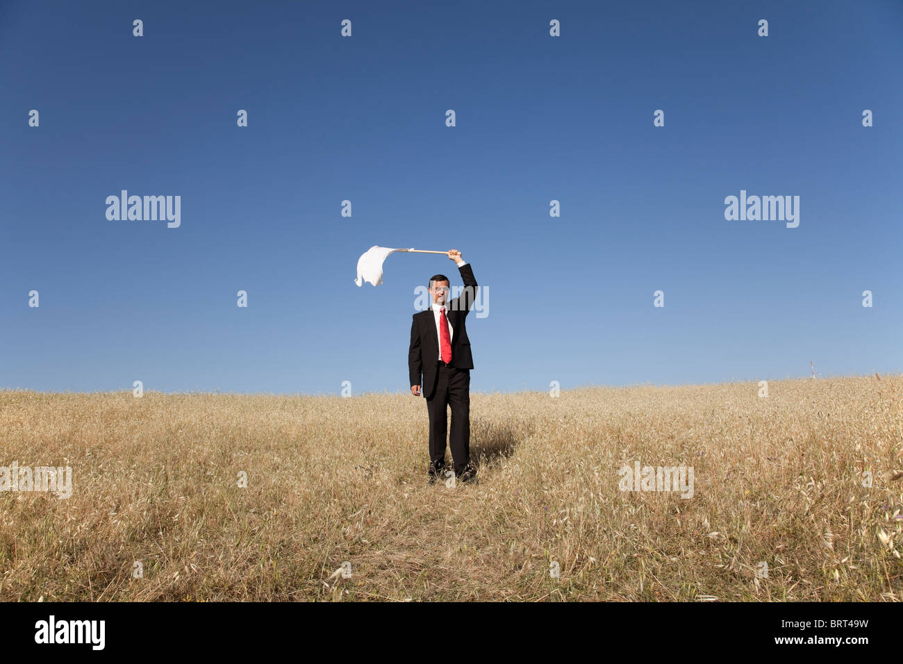 businessman asking for surrendering with a white flag Stock Photo - Alamy
