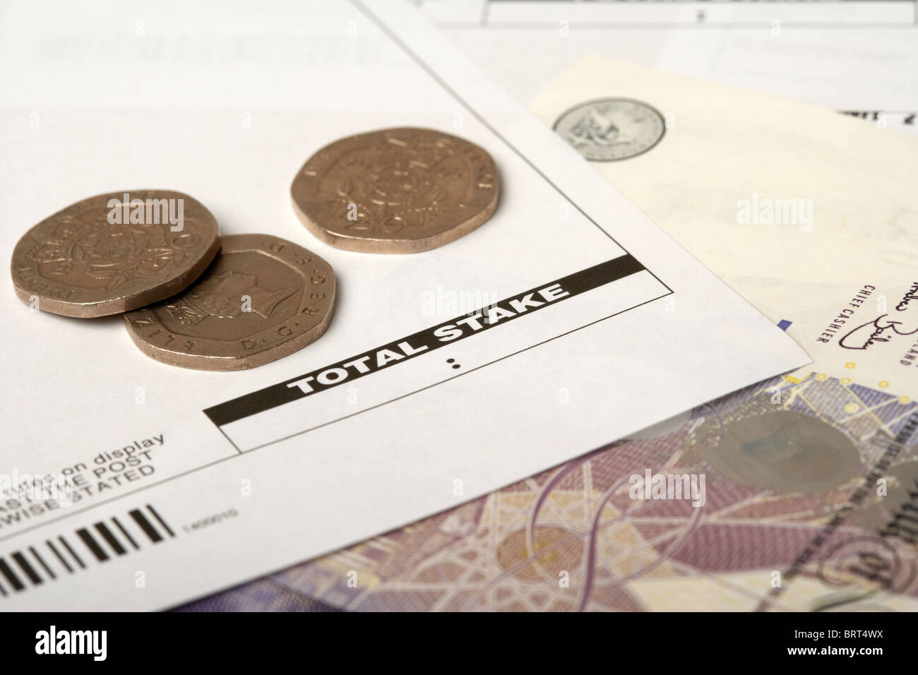 betting slip from a bookmakers showing total stake with coins and notes ...