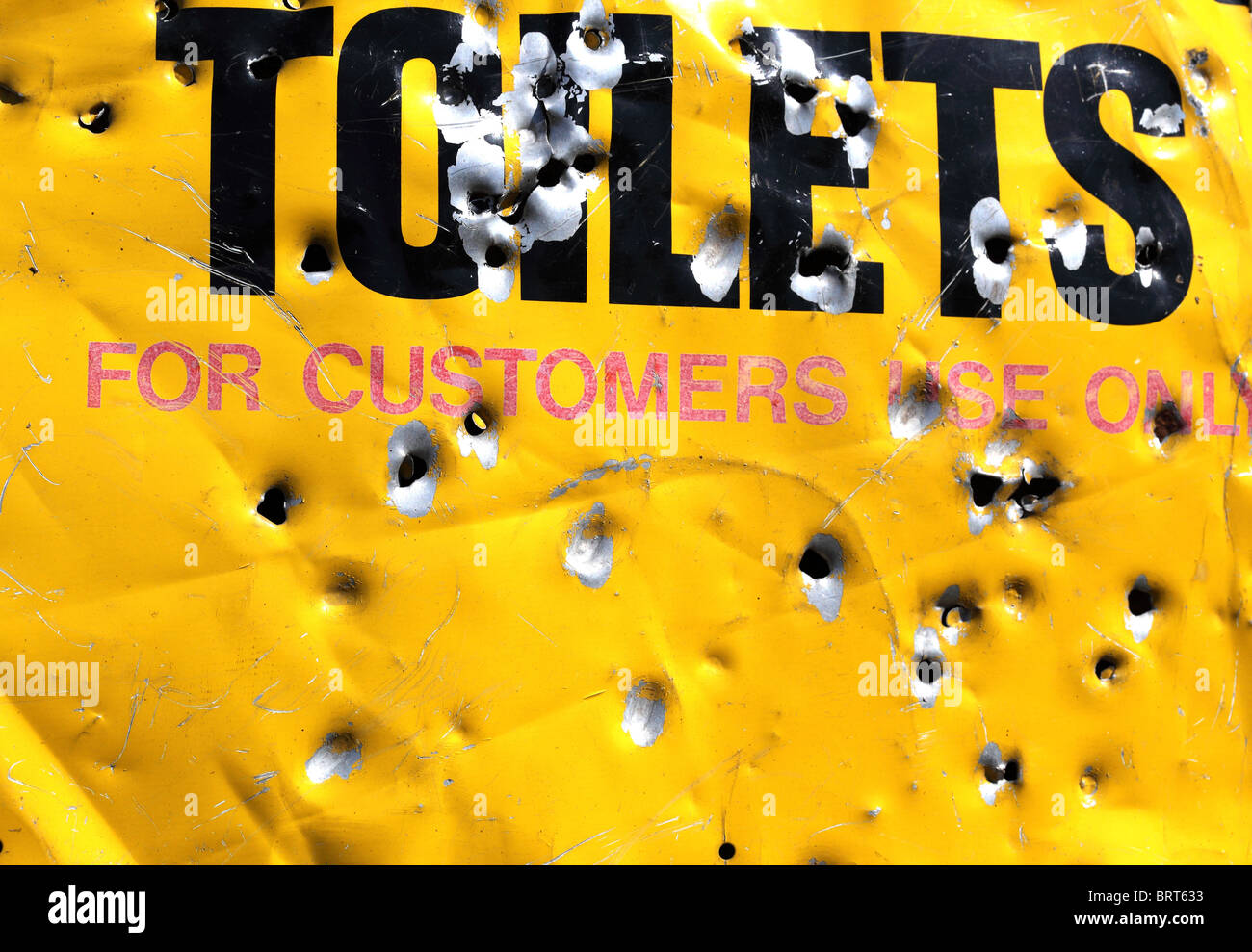 Toilet sign used as target practise with bullet holes Stock Photo - Alamy