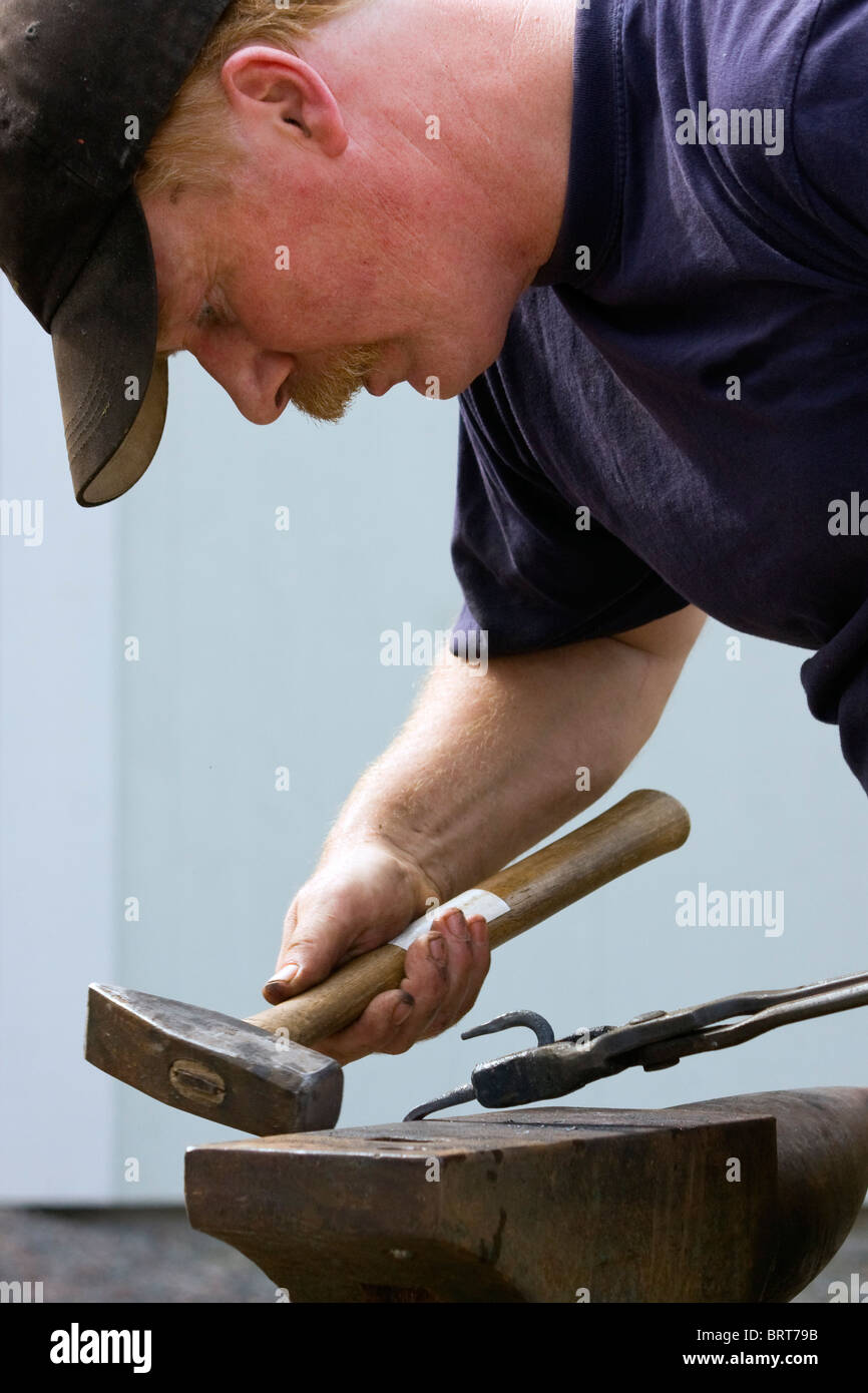 Blacksmith at work, using his hammer Stock Photo - Alamy
