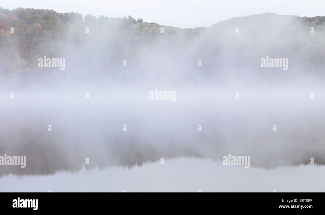 Early morning fall nature scenery of fog rising over The Arrowhead Lake ...