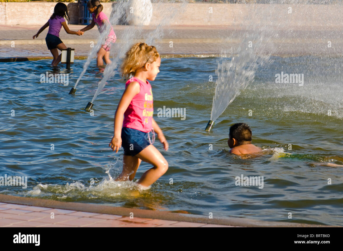 Kids playing in fountain Stock Photo - Alamy