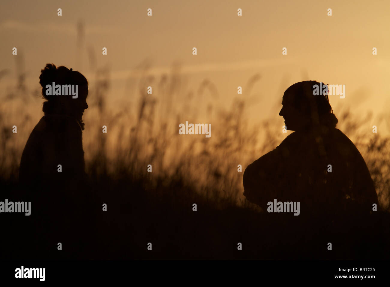 Two girls talking at sunset over the reef of Etretat Stock Photo - Alamy