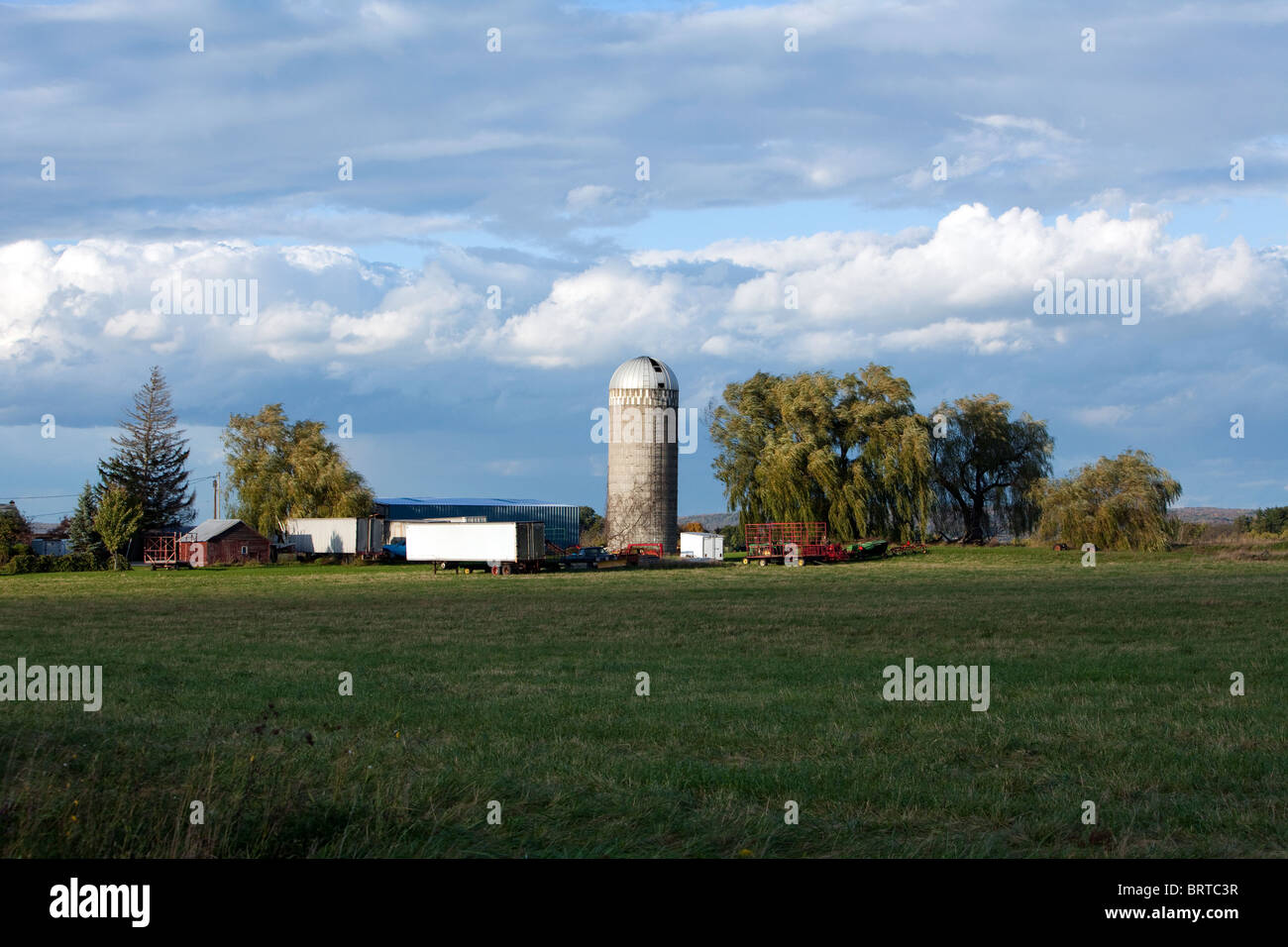 A farm with silos barns and a meadow with gathering storm cloud. Shot ...
