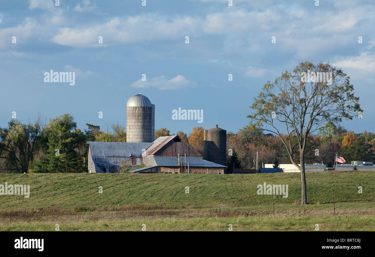 A farm with silos barns and a meadow with gathering storm cloud. Shot ...