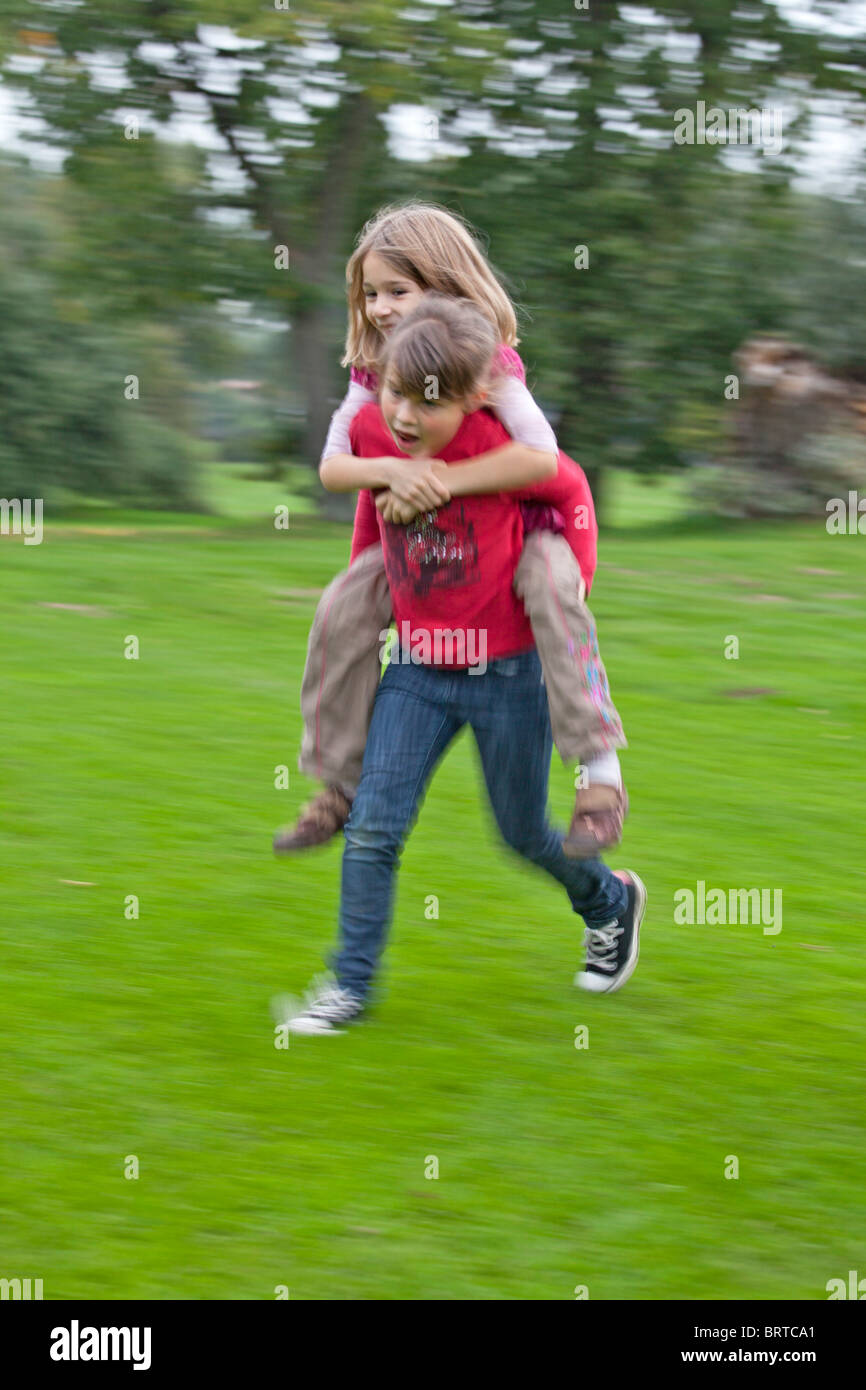young girl running with her friend piggyback Stock Photo - Alamy