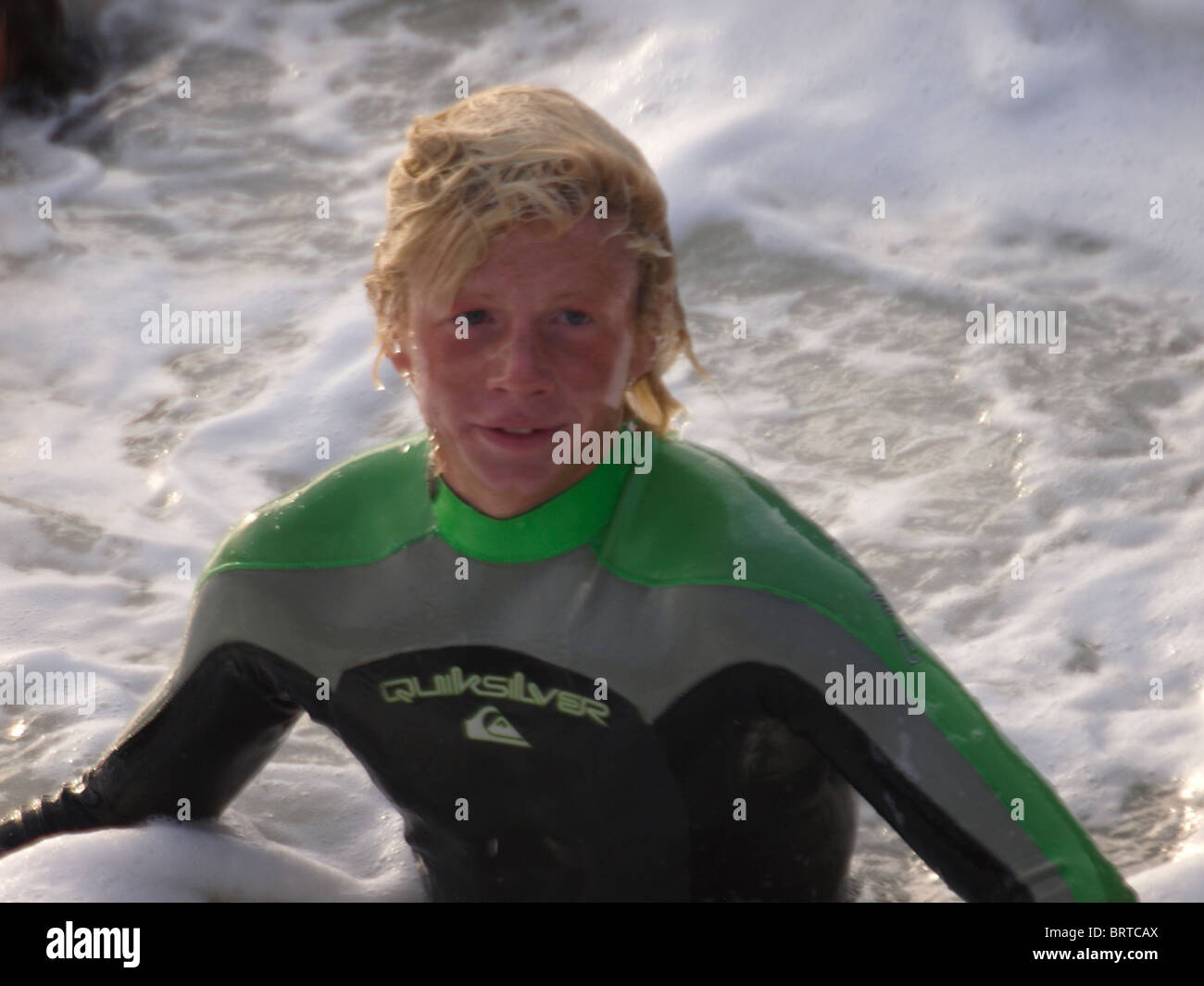 Young surfer coming to the surface from under a wave, Cornwall, UK ...
