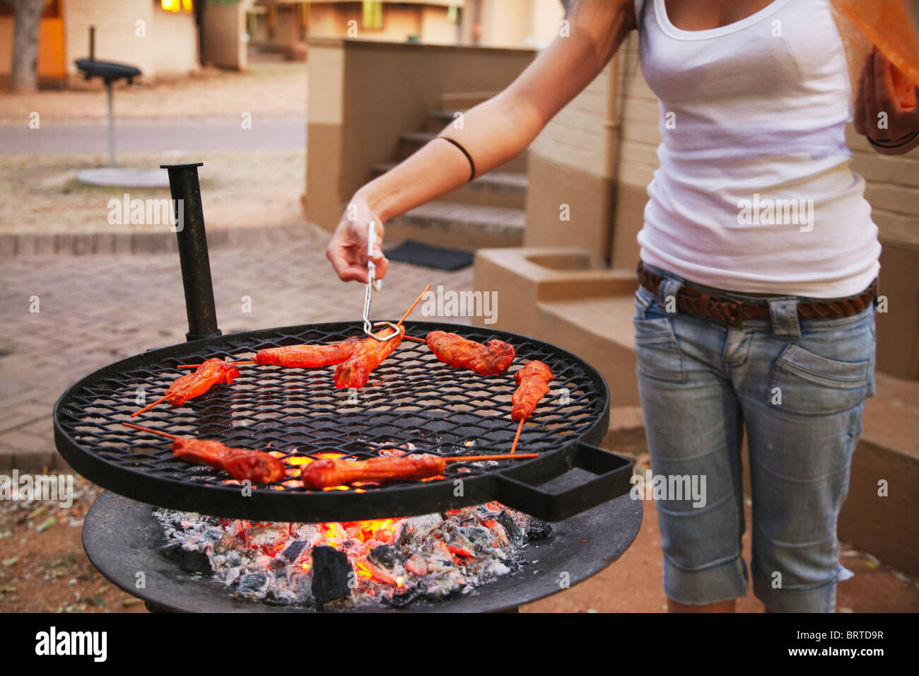 Woman cooking meat on barbecue at Skukuza Rest Camp, Kruger National ...