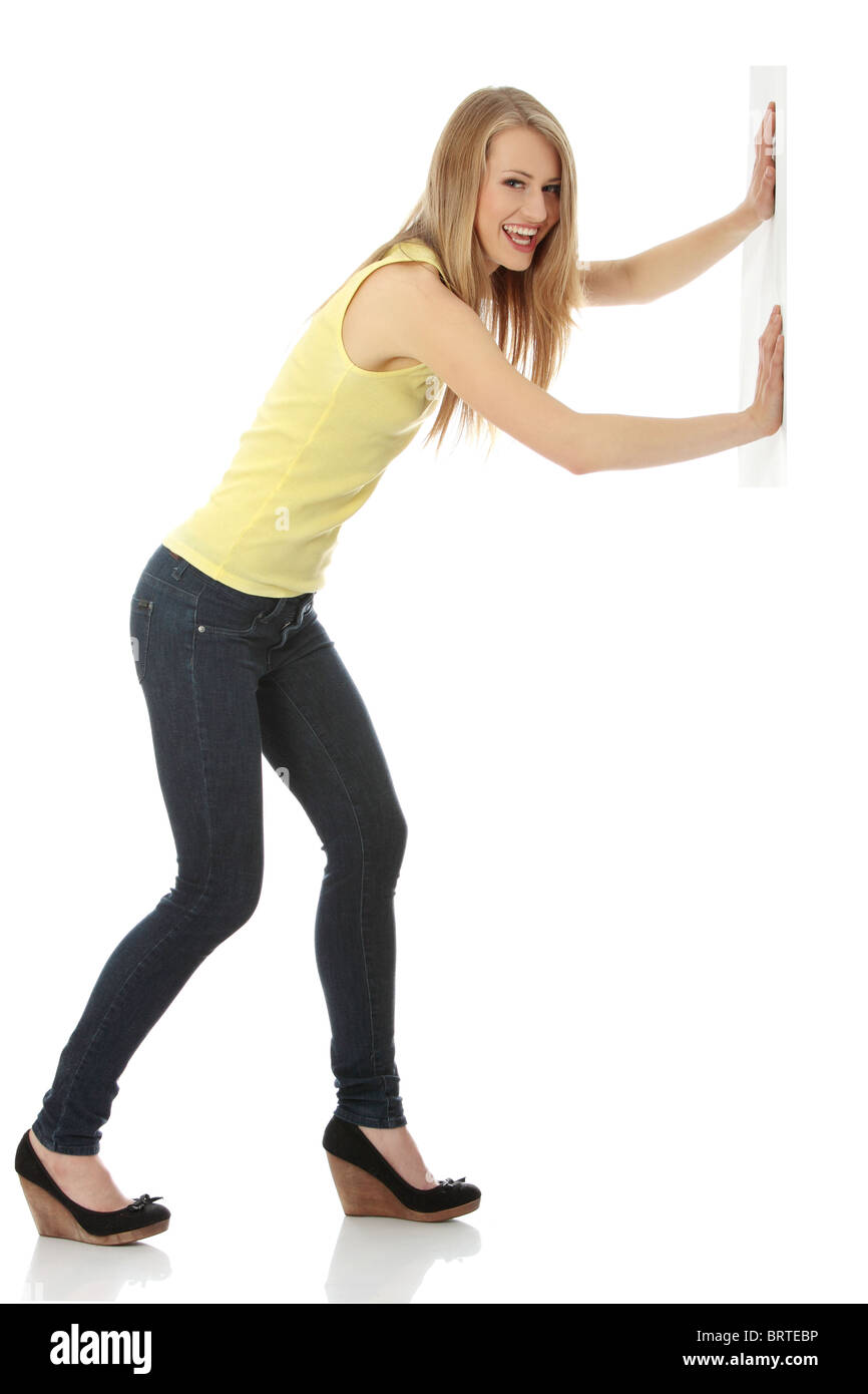 Woman pushing something imaginary isolated over a white background ...