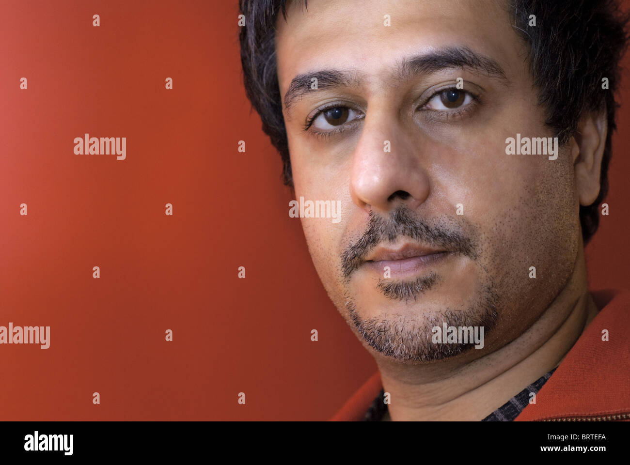 Portrait of Indian man with goatee beard, neutral expression, red ...