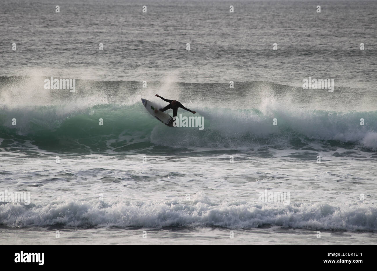 Surfer on board riding a wave Stock Photo - Alamy