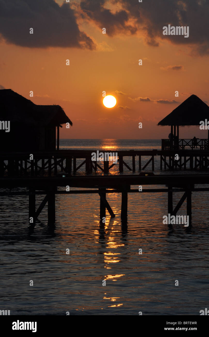 sunset maldives water bungalow huts Stock Photo - Alamy