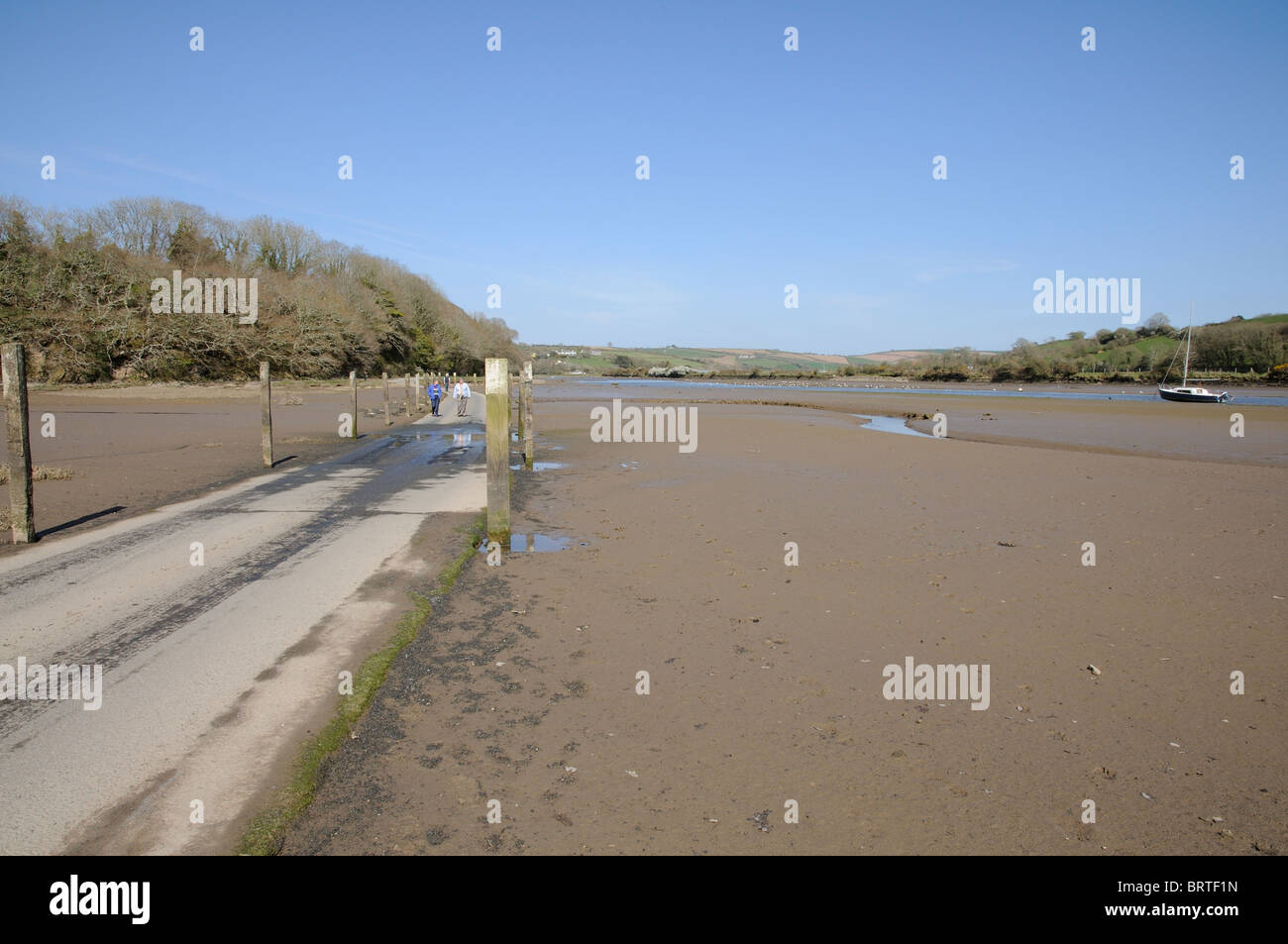 Women walking along a Tidal road alongside the River Avon between ...