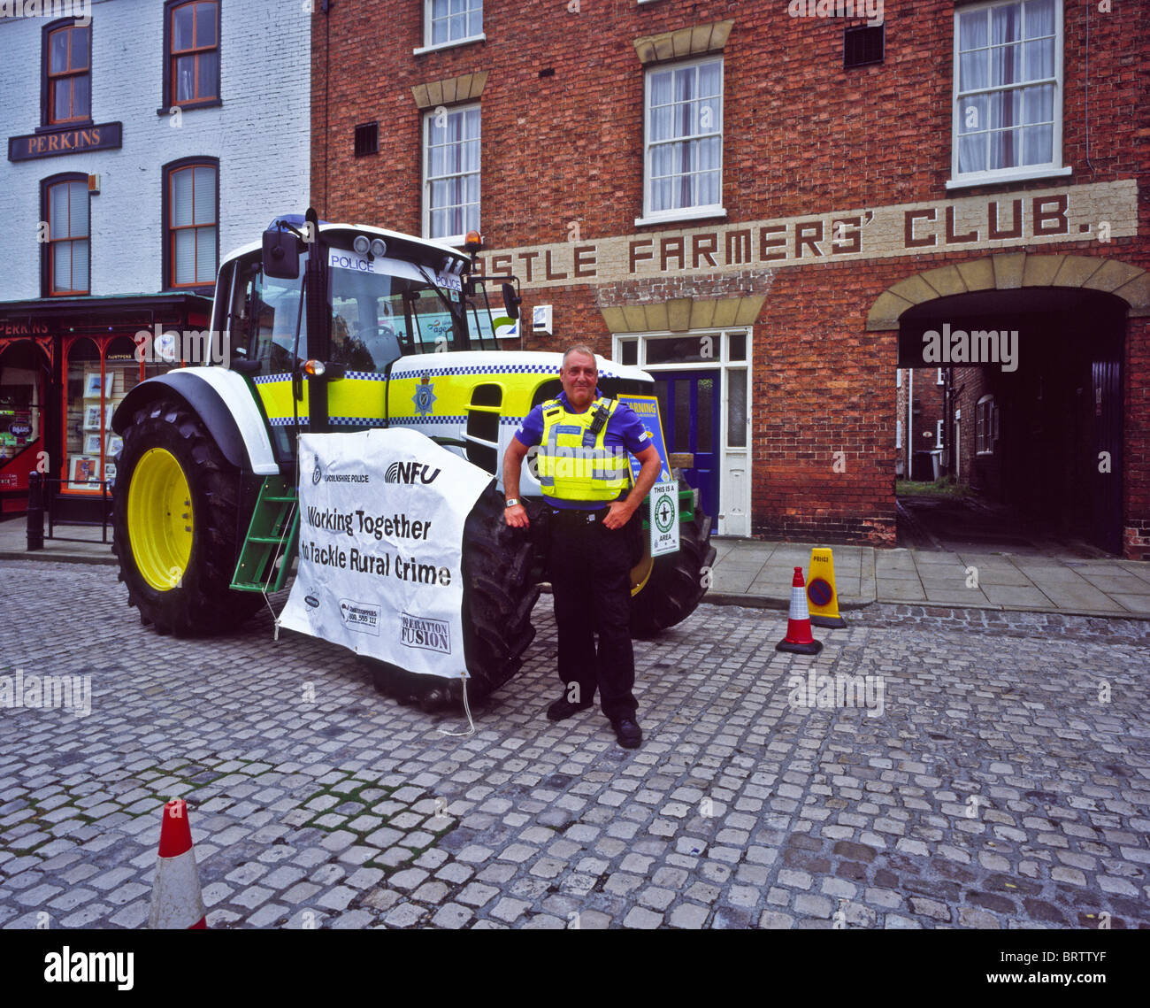 A police officer stood near a John Deere tractor in police livery used ...