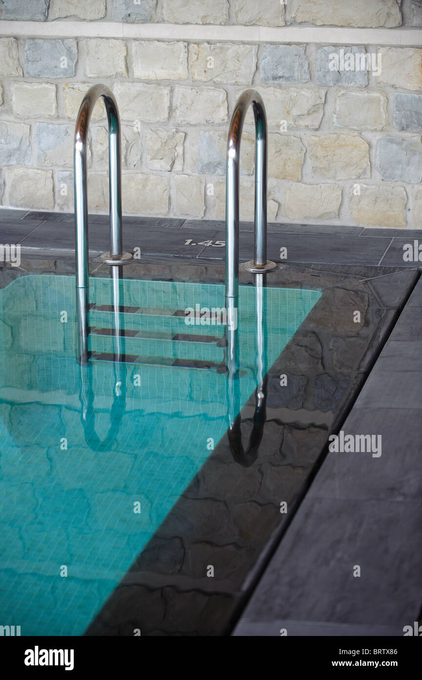 Indoor swimming pool entry ladder Stock Photo - Alamy