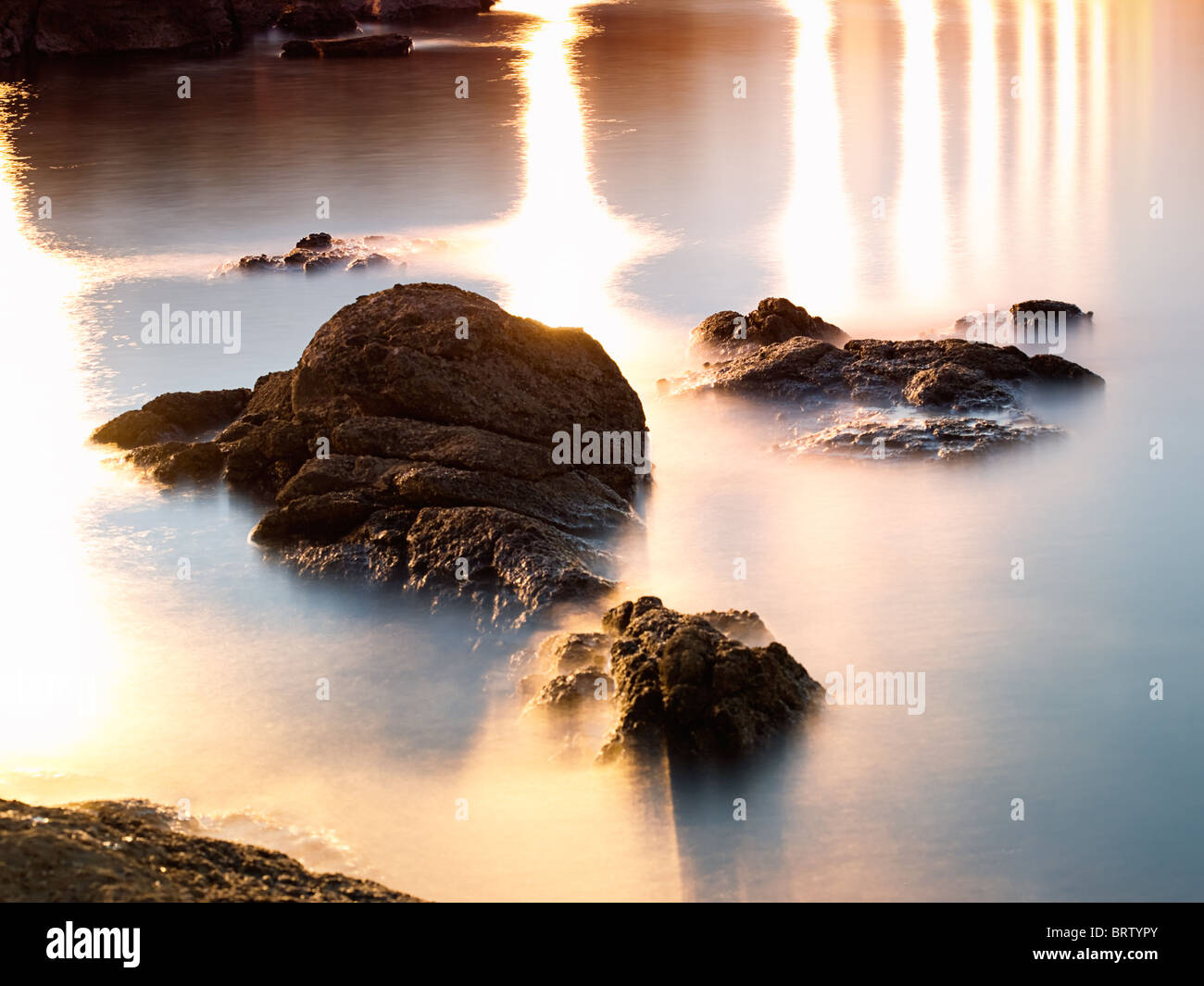 Sea surface and rocks lighten by artificial light in some port by night ...